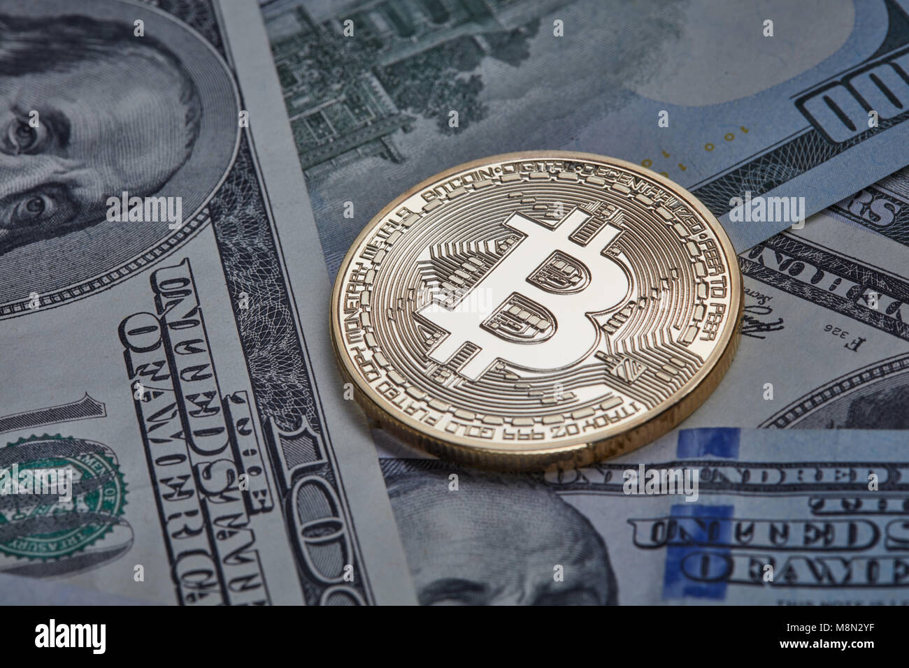 One gold coin in the background of dollar bills Stock Photo - Alamy