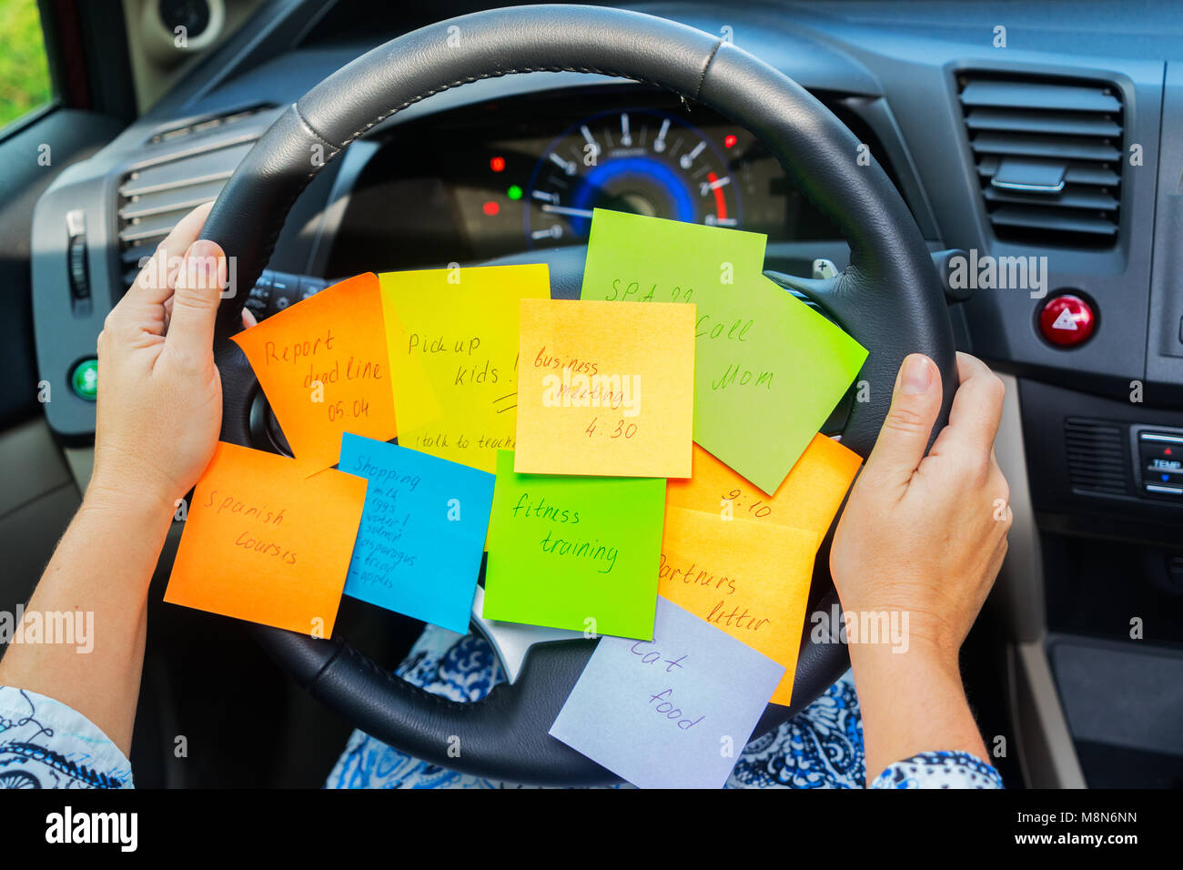 Two hands holding driving wheel and to do list in a car - busy day ...