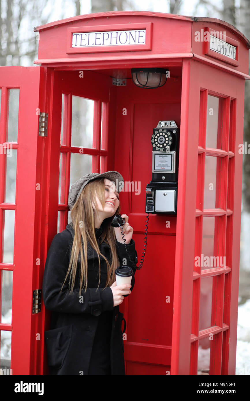 Beautiful young girl in a phone booth. The girl is talking on th Stock ...