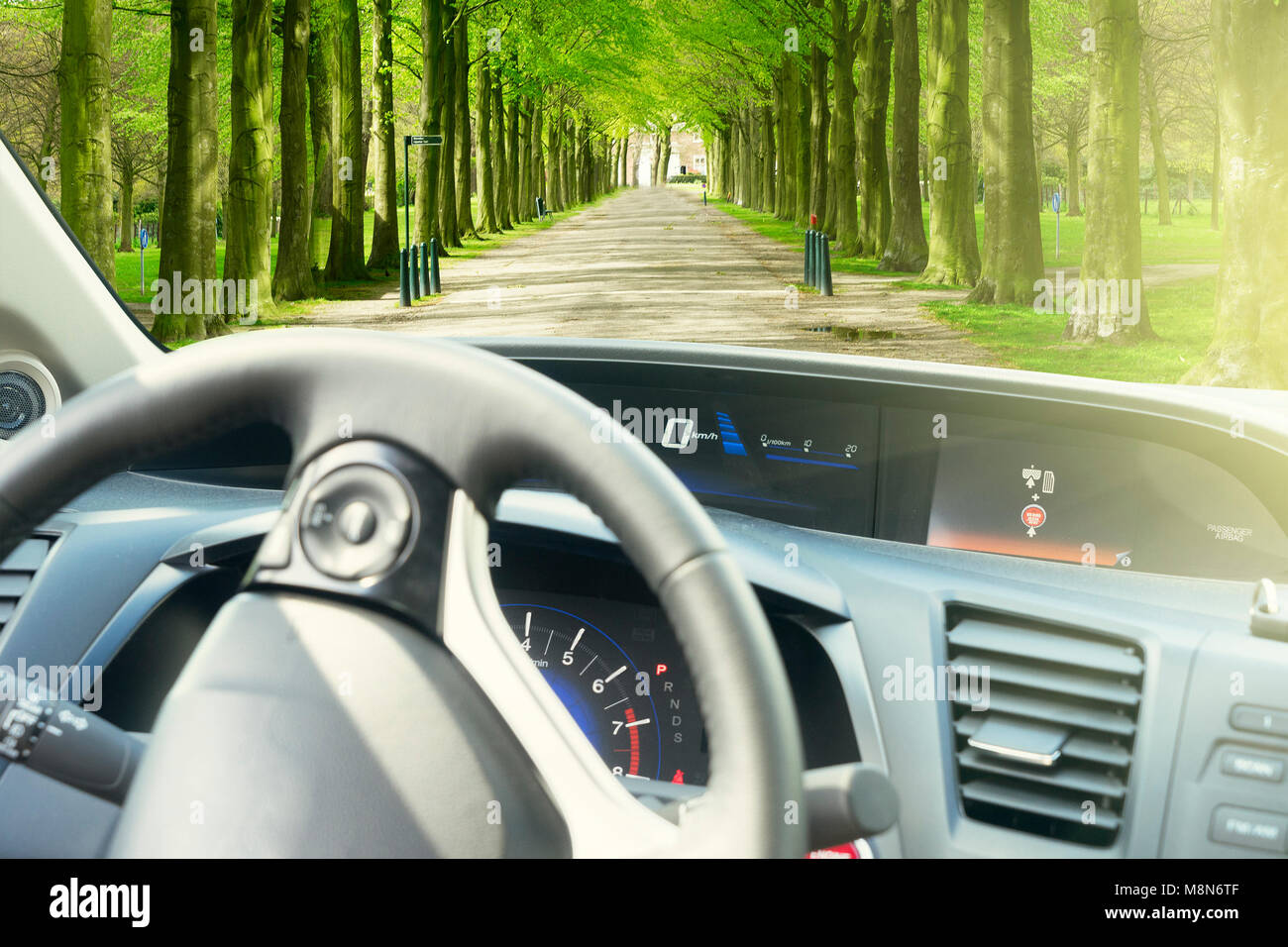 car driving wheel with dashboard with inside out view on spring road ...