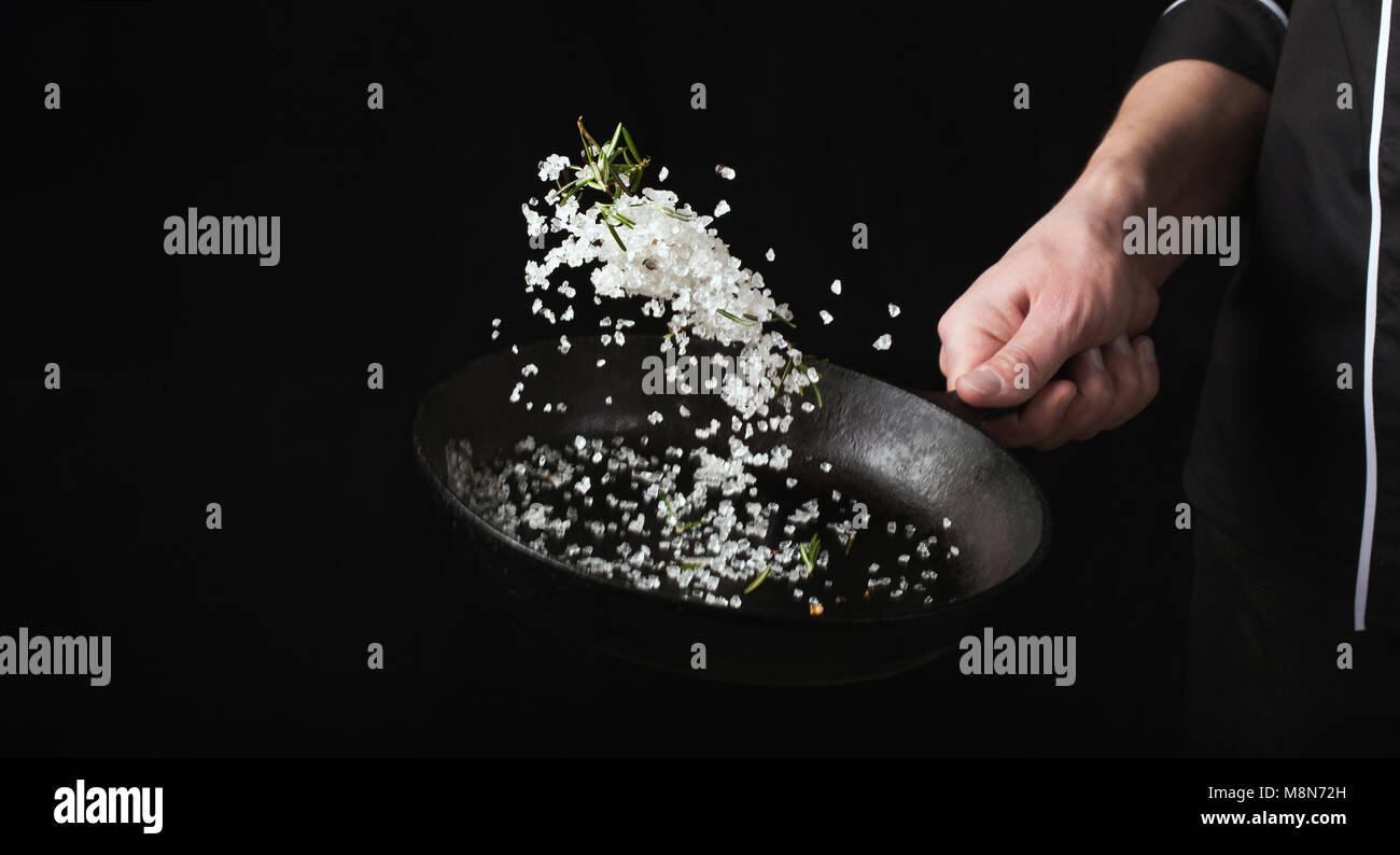 Cooking roasted aromatic salt in a pan by chef hand. Horizontal photo ...