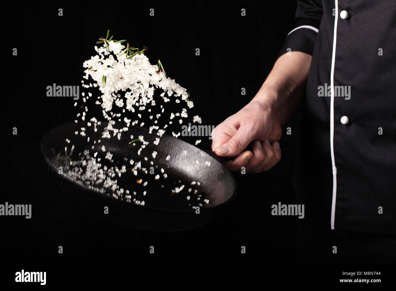 Cooking roasted aromatic salt in a pan by chef hand. Horizontal photo ...