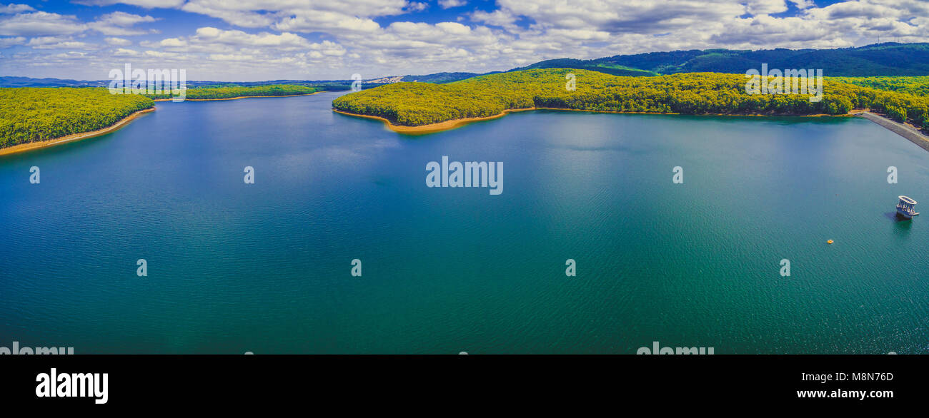 Aerial panorama of Silvan Reservoir lake and forest under fluffy clouds ...
