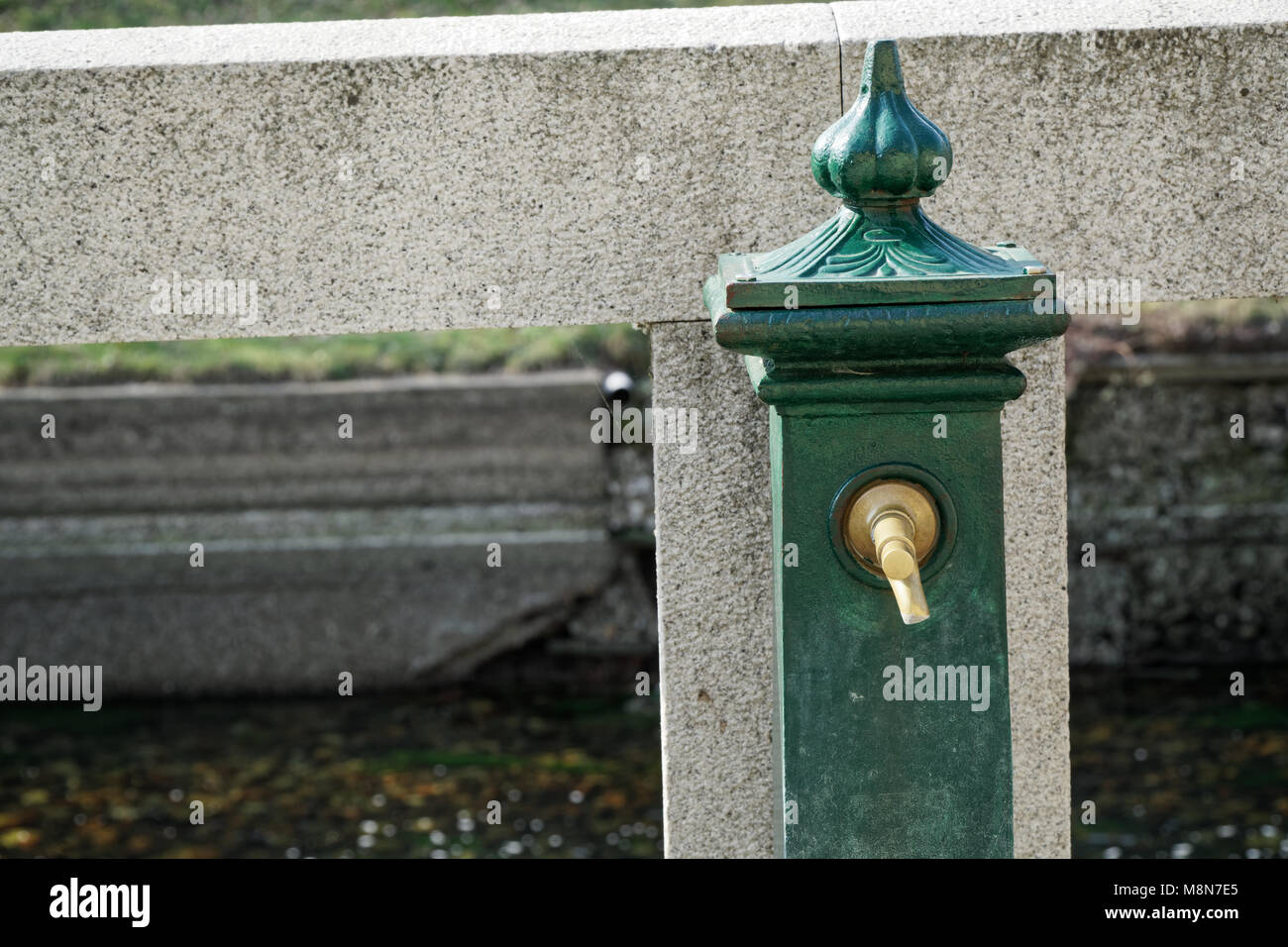 Urban water well on public park in spring time. Water source in the ...