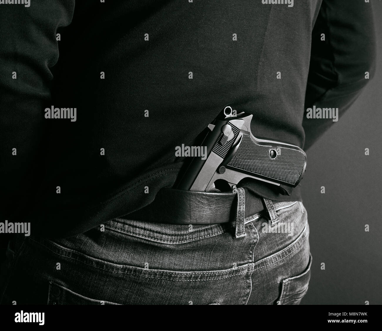 gangster concealing his gun behind his back. back and white photo Stock ...