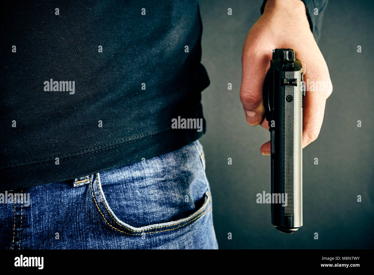 Man with gun in hand Stock Photo - Alamy