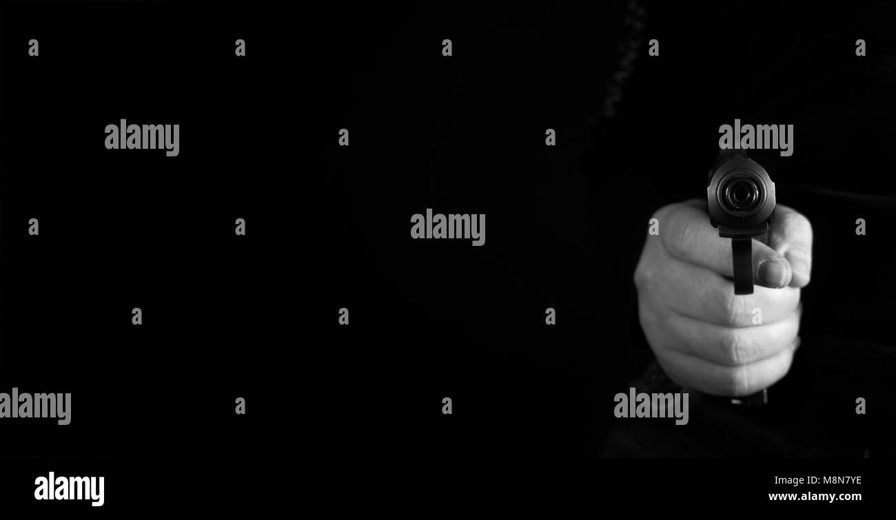 a man hand pointing a gun forward black and white photo Stock Photo - Alamy