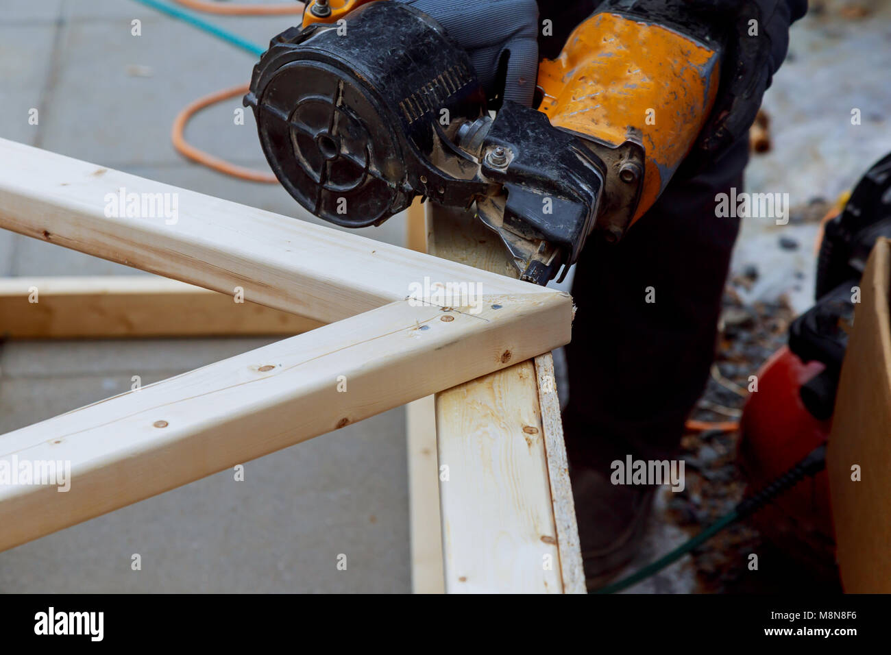 The worker makes finishing works of walls with a white wooden board ...