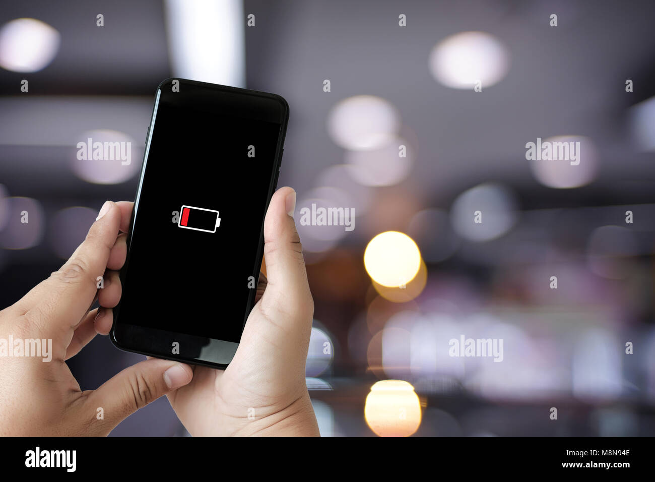Close up man hands using smart phone battery low charged battery screen ...