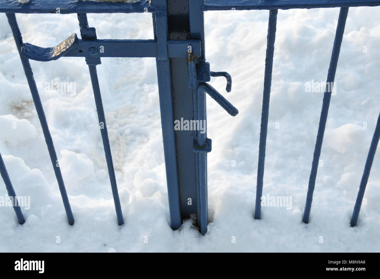 a latched metal gate surrounded by snow Stock Photo - Alamy