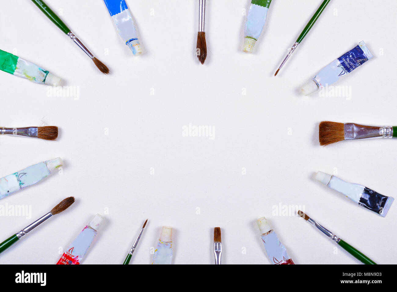 Paint brushes and color tubes placed in diagonal direction isolated on ...