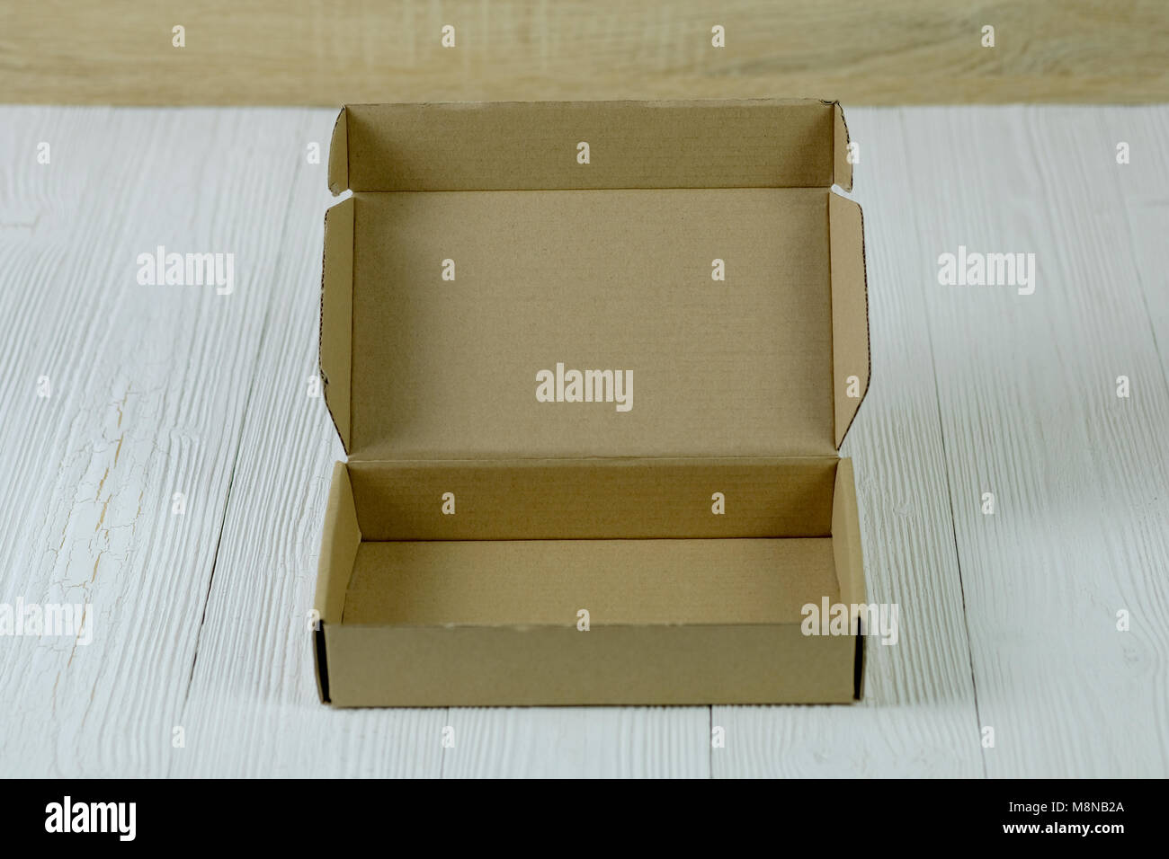 Empty Package brown cardboard box or tray on bright white wooden table ...