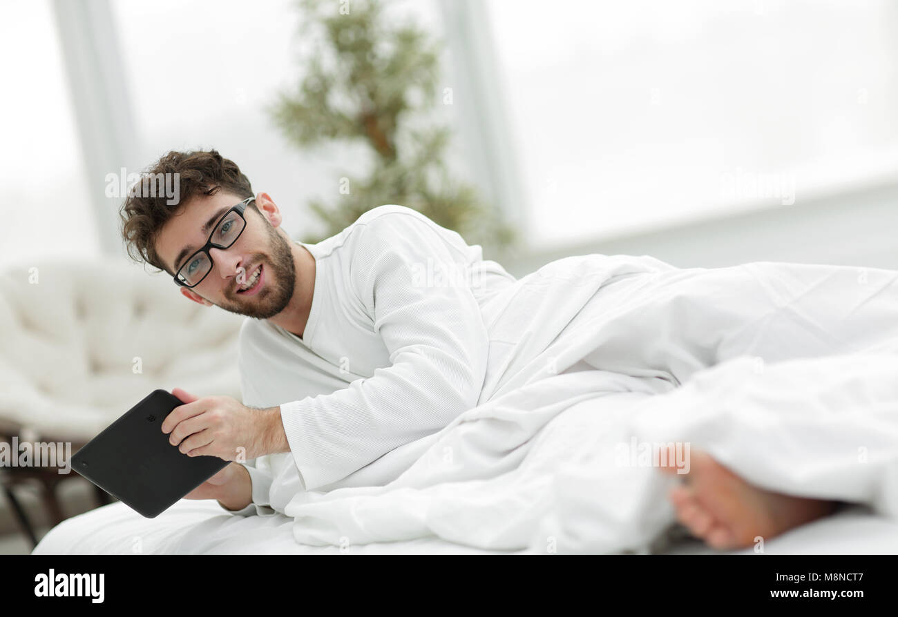 closeup.sleepy man taking digital tablet Stock Photo - Alamy