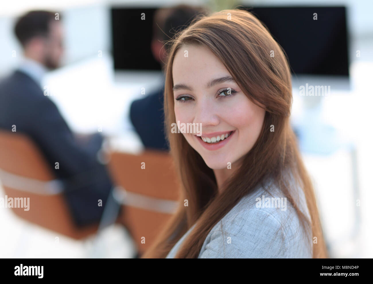 smiling female assistant in the background of the office Stock Photo ...