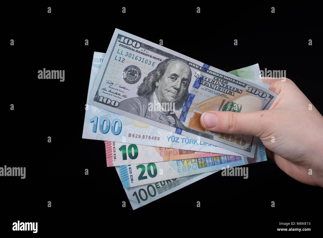 Hand holding American dollar banknotes isolated on black background ...