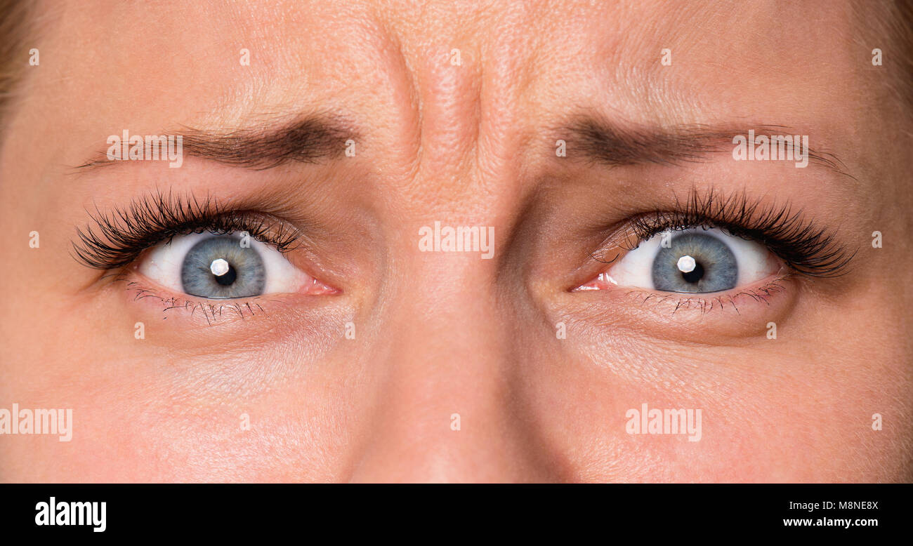 Close-up scared face of beautiful young woman with beautiful blue eyes ...