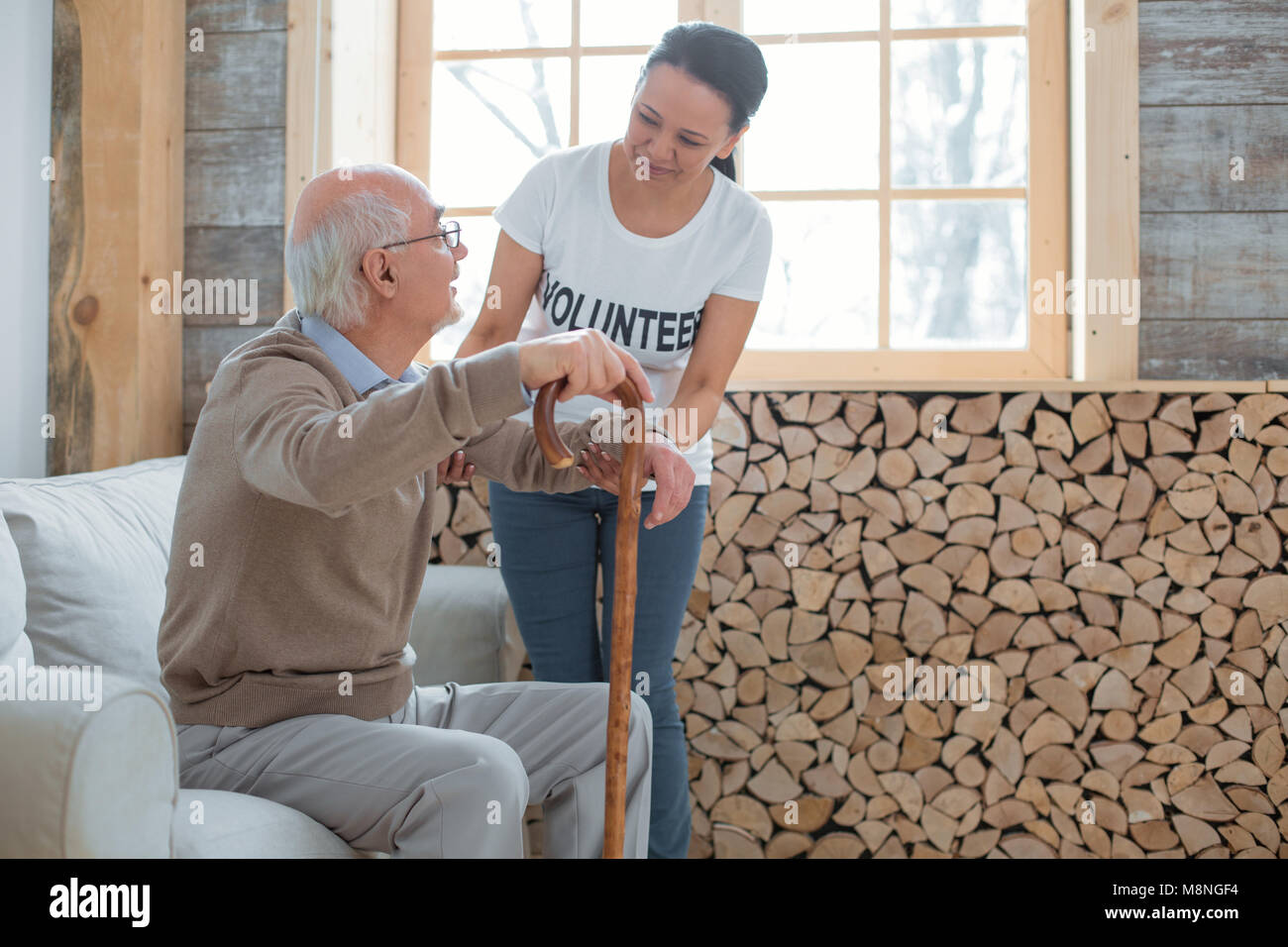 Adorable volunteer helping senior man Stock Photo - Alamy