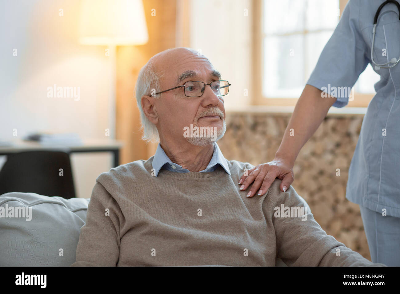 Doctor calming down sad senior man Stock Photo - Alamy