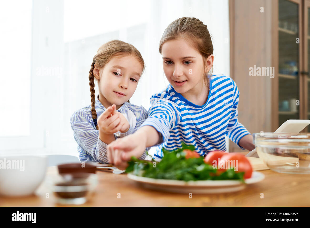 Two Cute Girls Cooking at Home Stock Photo - Alamy