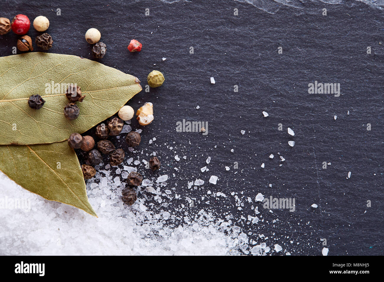 Composition of bay laurel leaf with peppercorn and salt isolated on ...