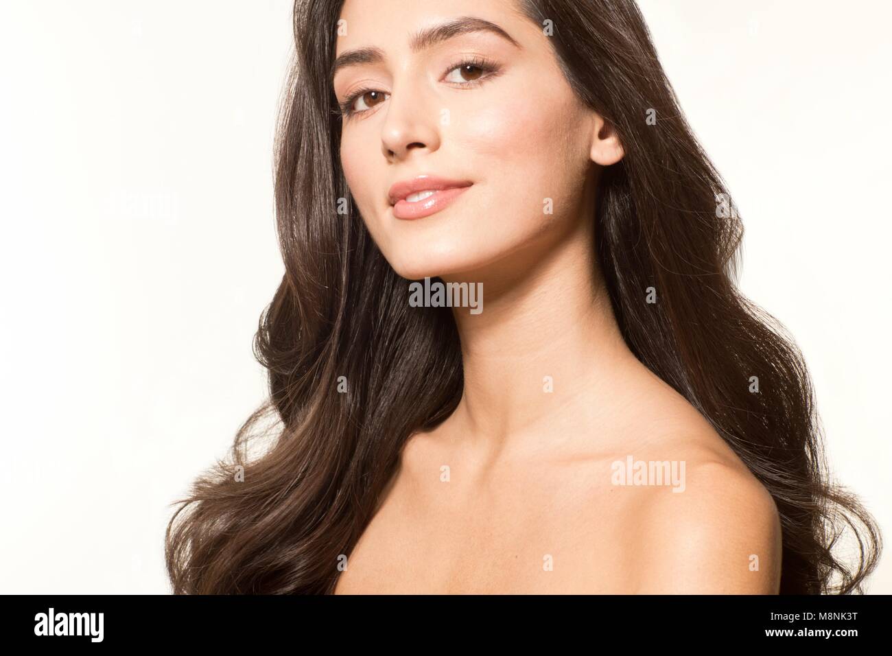 MODEL RELEASED. Young woman with long brown hair looking at camera ...