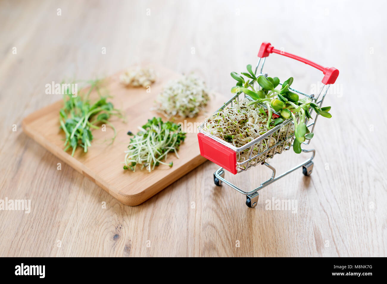 Micro greens in shopping cart on wooden background. Different types of ...