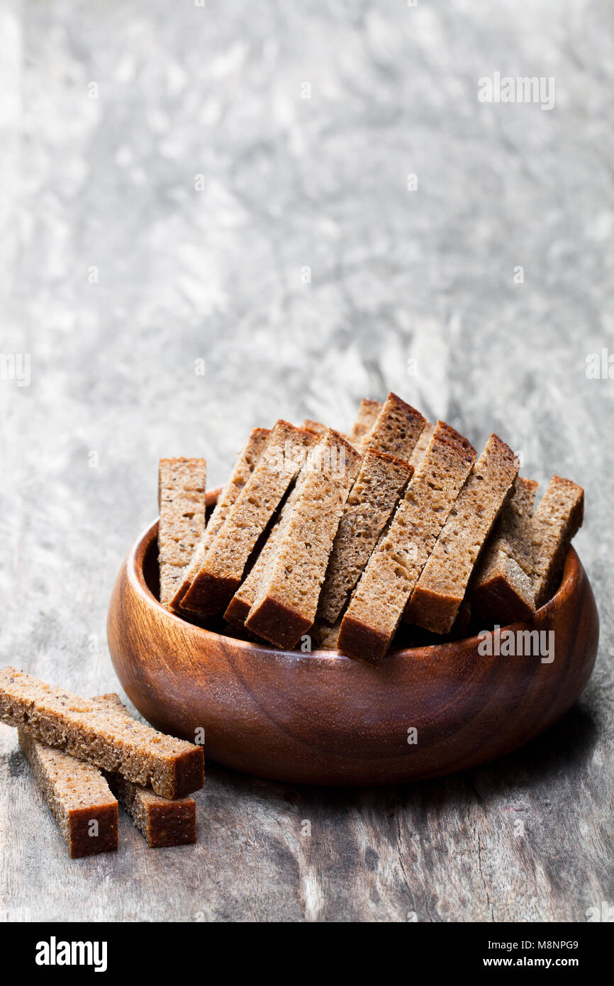 Rye bread crackers in wooden bowl on rustic wooden table Stock Photo ...