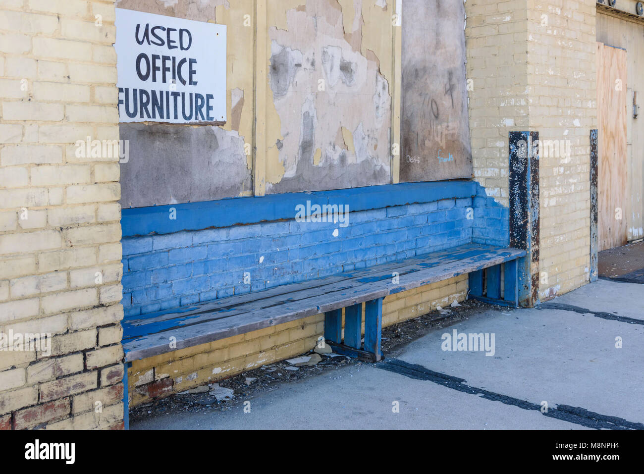 inner city scene blue painted bench outside old abandoned brick ...