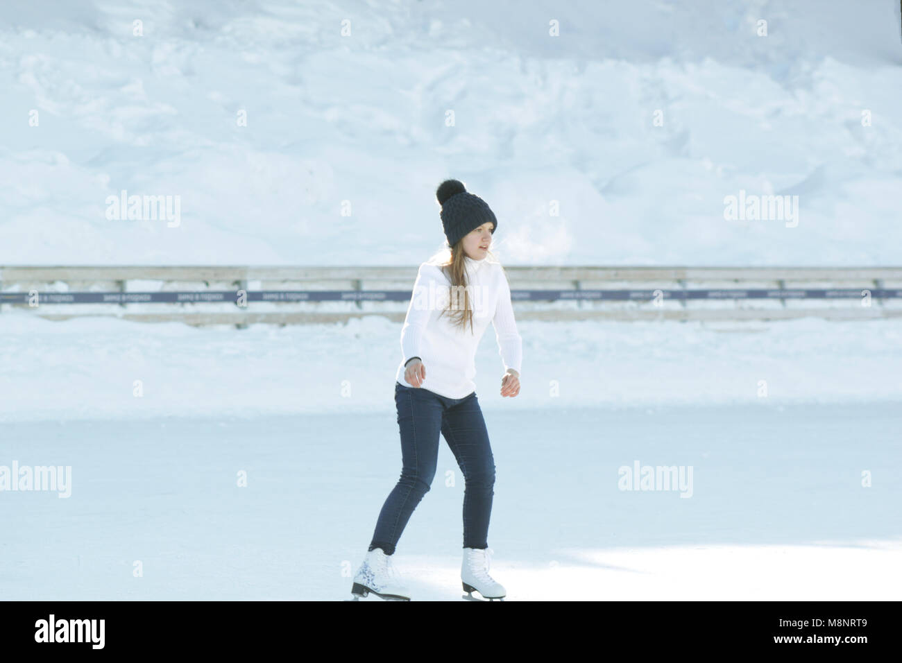 Teen girl skating on outdoor public ice rink Stock Photo - Alamy