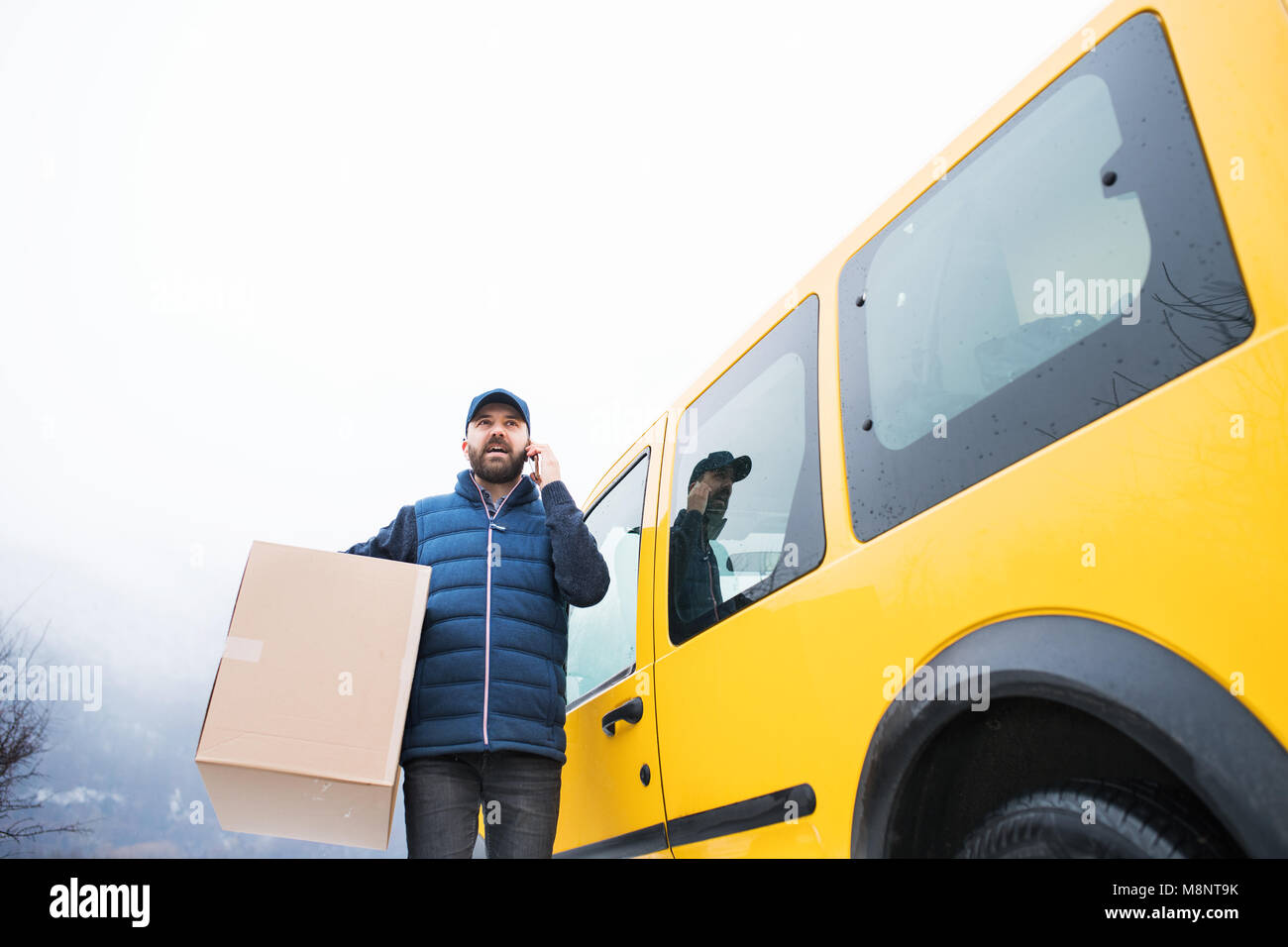 Delivery man delivering parcel box to recipient Stock Photo - Alamy