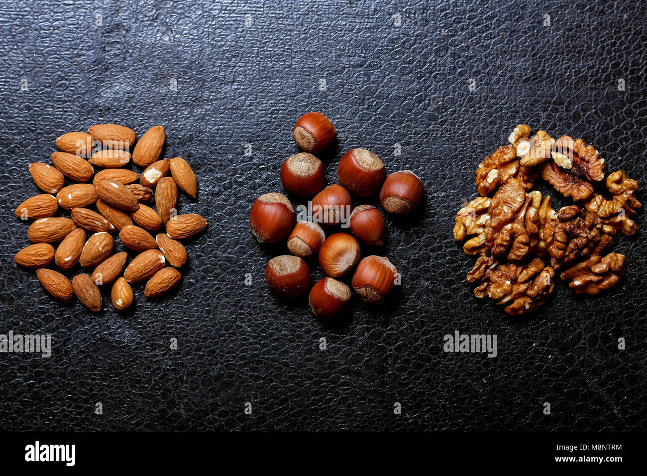 Nuts lying on the table by the handful Stock Photo - Alamy