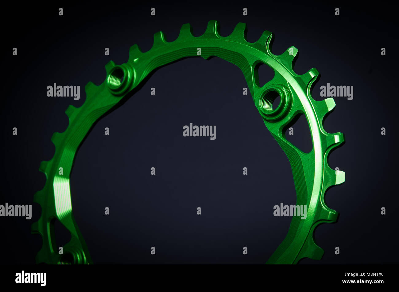 Green oval bicycle chainring at dark blue background Stock Photo - Alamy