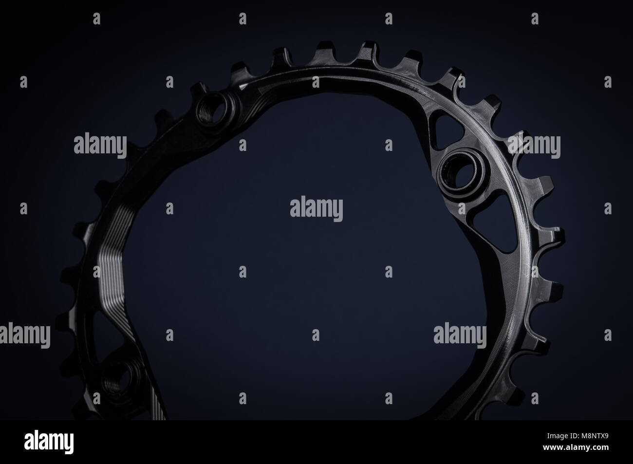Black oval bicycle chainring at dark blue background Stock Photo - Alamy