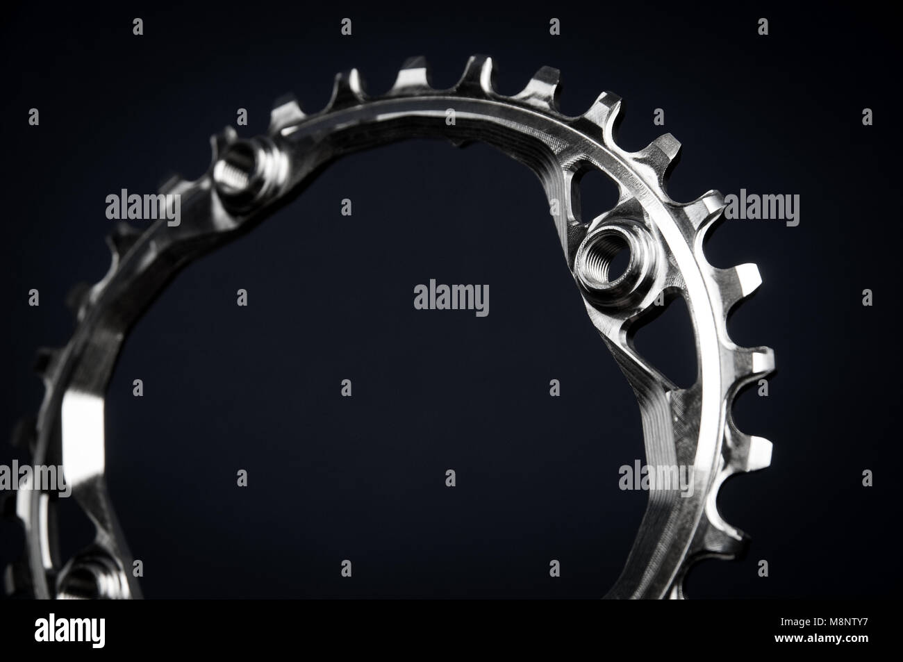 Silver round bicycle chainring at dark blue background Stock Photo - Alamy