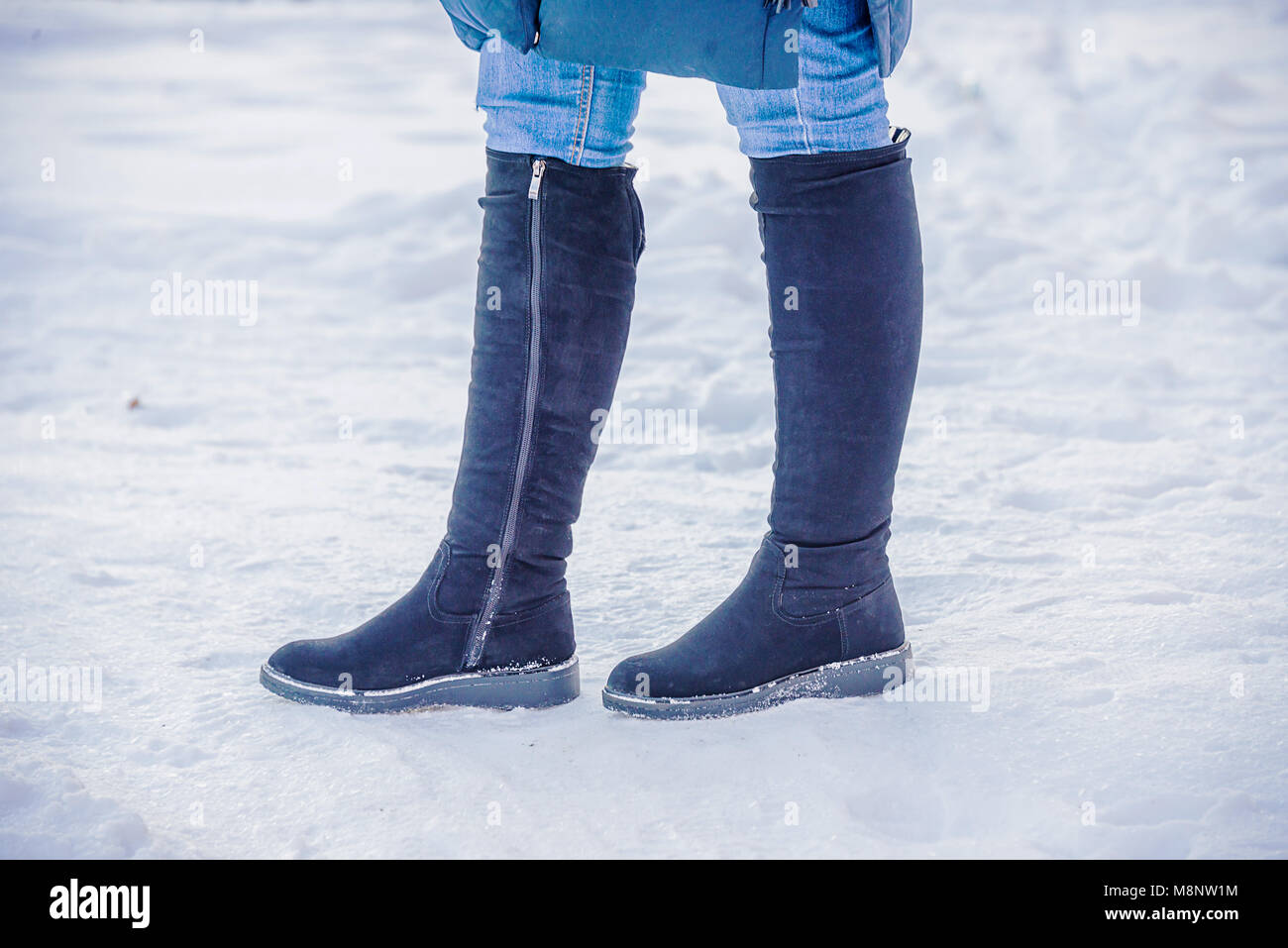women's feet in boots, in winter in the snow, cold crooked feet, winter ...