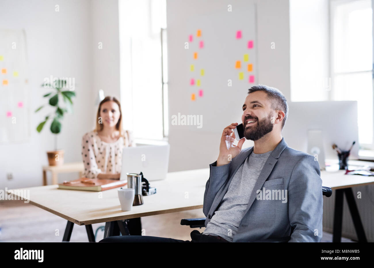 Two business people with smartphone in the office Stock Photo - Alamy