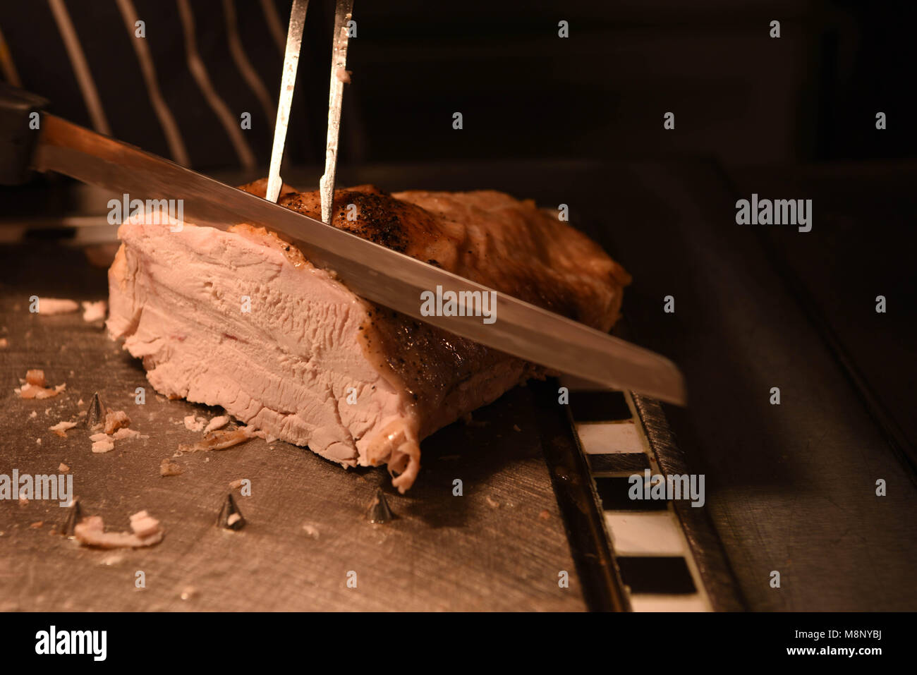 roast turkey meat being carved with carving knife and fork and chef in ...