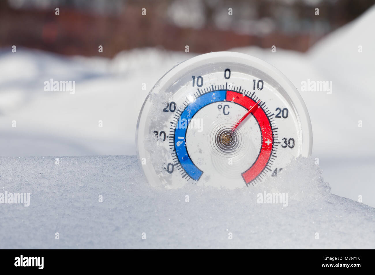 Thermometer with celsius scale in melting snow showing plus 13 degree ...