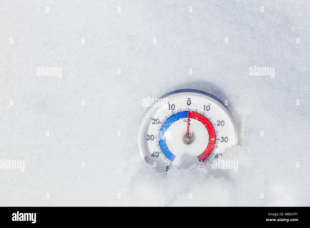 Thermometer with celsius scale placed in a snow showing zero ...