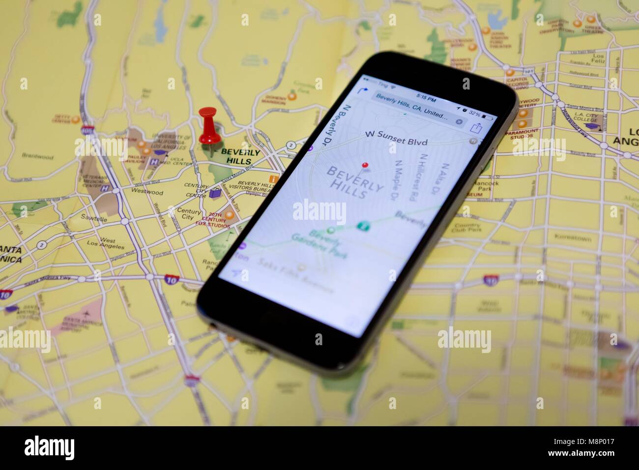 iPhone with Apple Map app, sitting on an conventional street-map, in ...