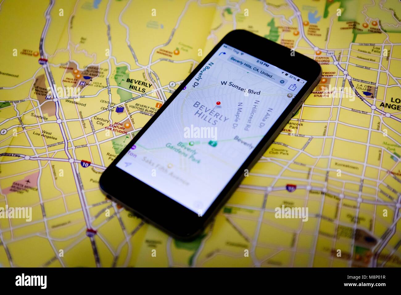 iPhone with Apple Map app, sitting on an conventional street-map, in ...