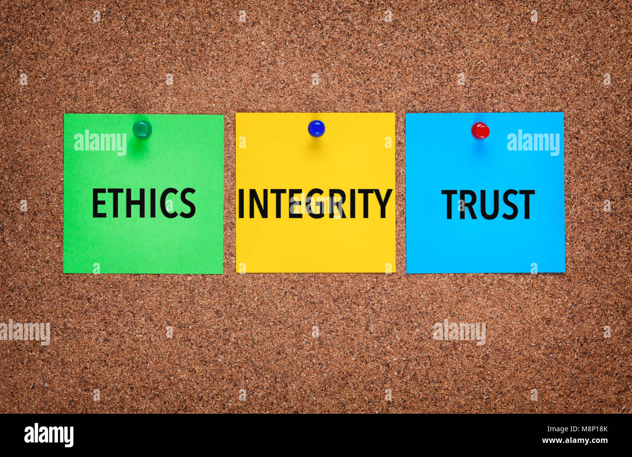 Three notes on corkboard with words Integrity, Trust, Ethics. Close-up ...