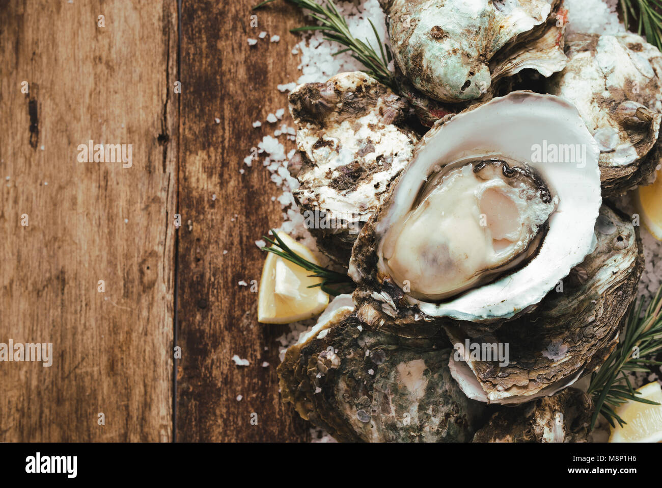 A photo of freshly opened oysters on a wooden background texture with ...