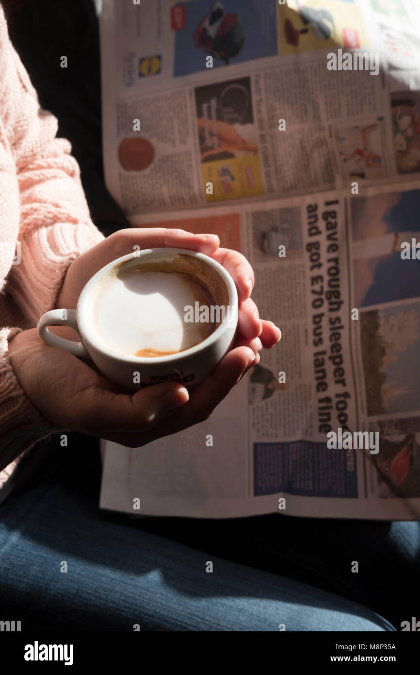 Woman hold cappuccino and reading newspaper-Close-up,London,UK Stock ...