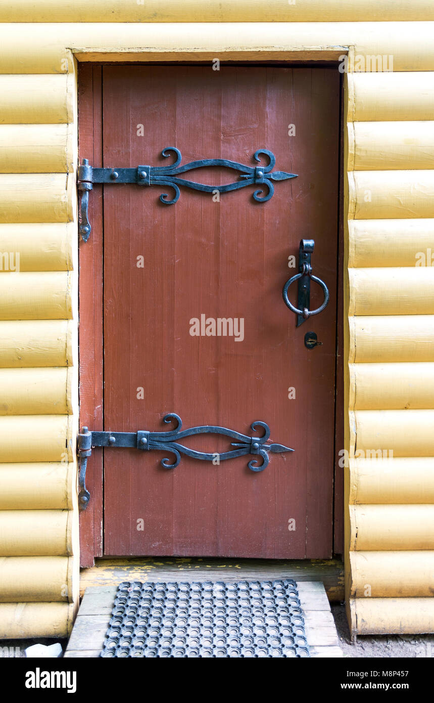Traditional russian wooden door with forged massive metal hinges in the ...