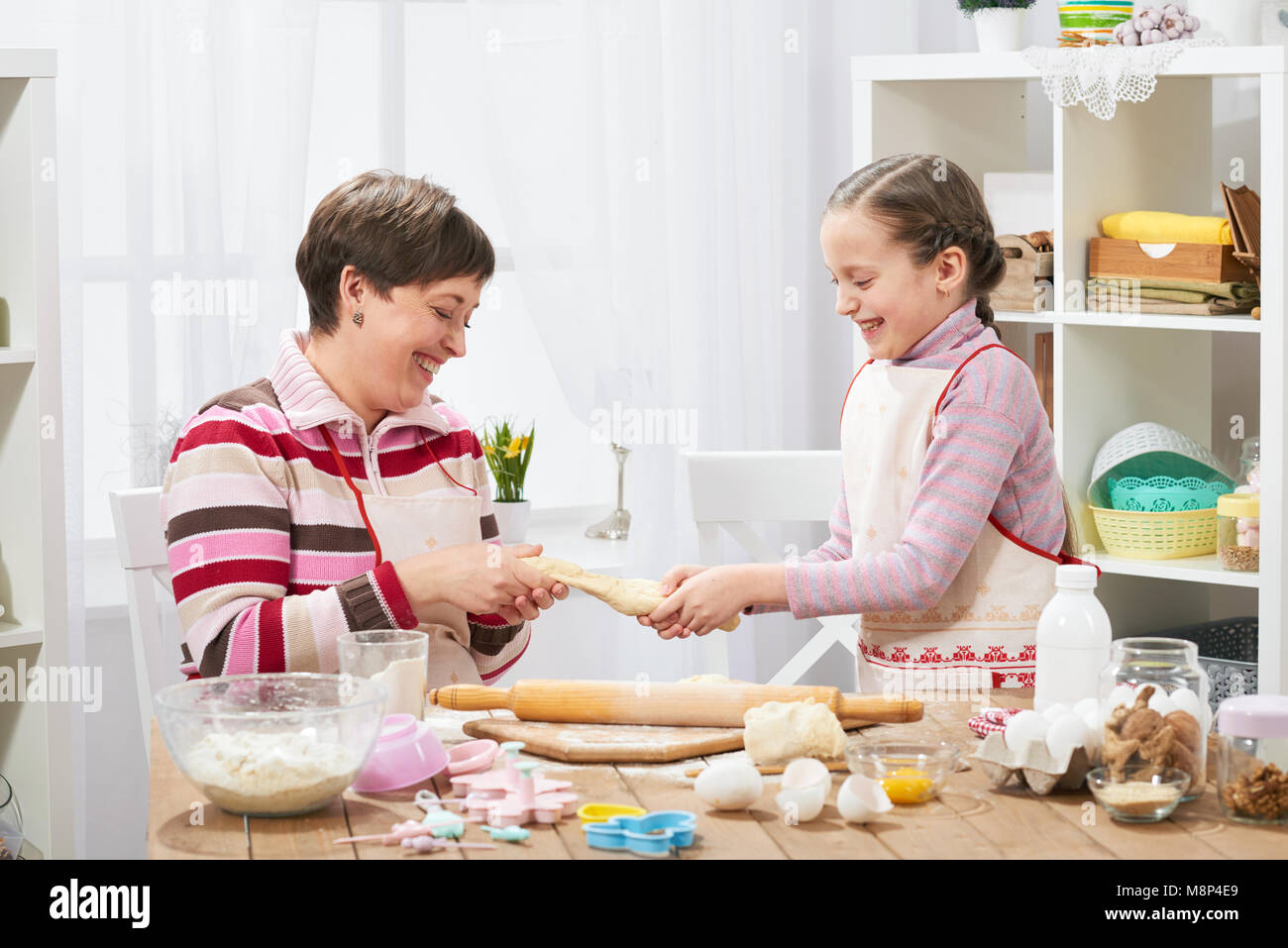 Mother and daughter cooking at home, making the dough for buns Stock ...