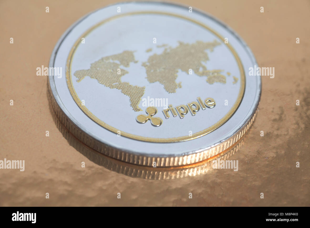 Golden ripple coin on a gold background Stock Photo - Alamy