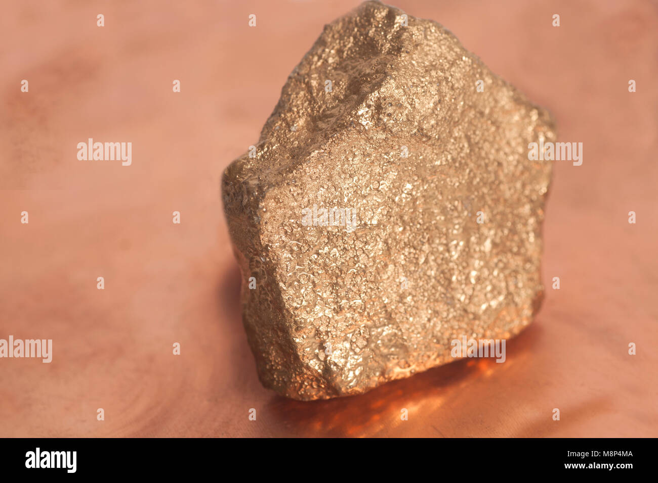Golden nugget bar on a copper background Stock Photo - Alamy