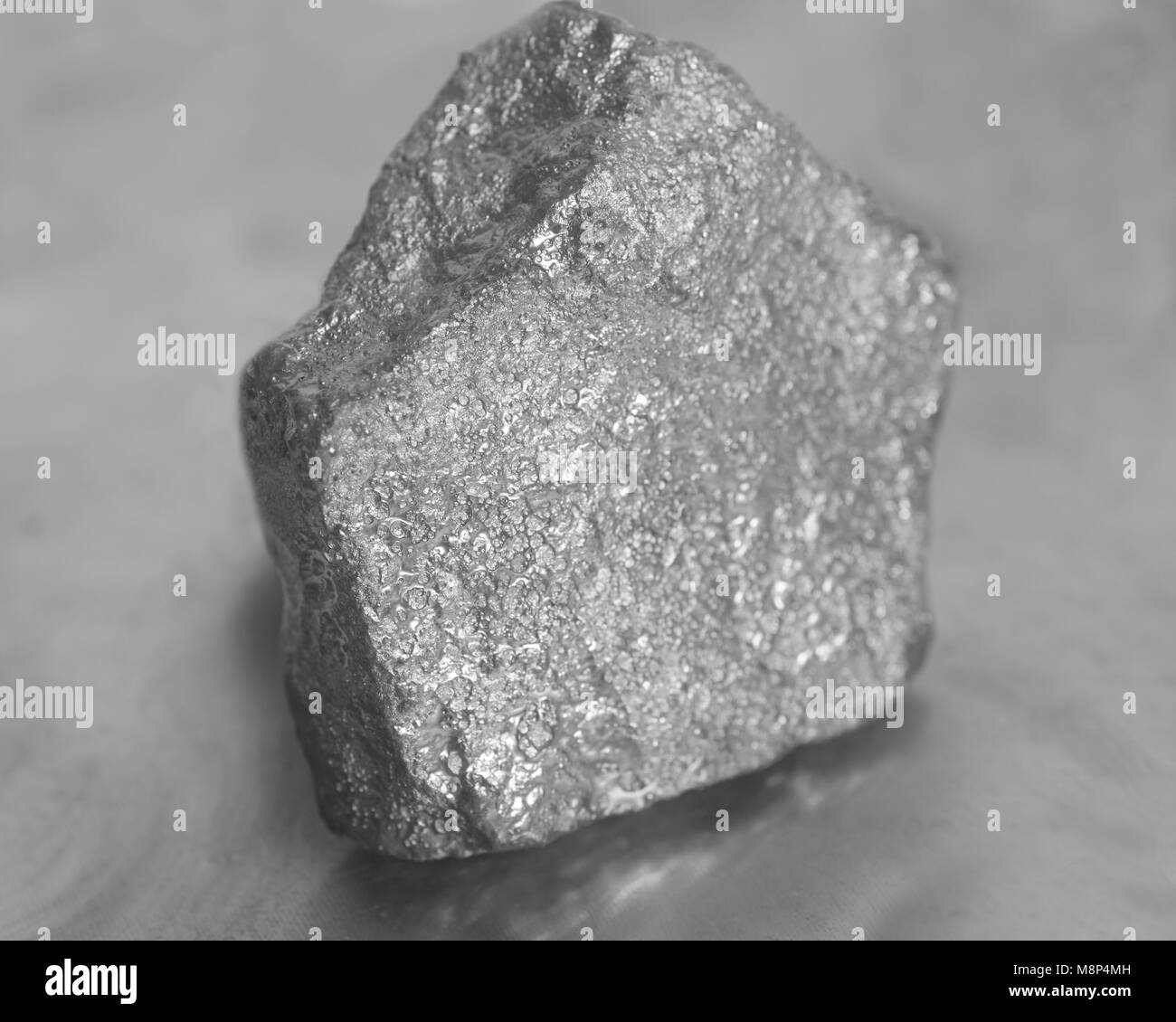 Silver nugget bar on a gray background Stock Photo - Alamy