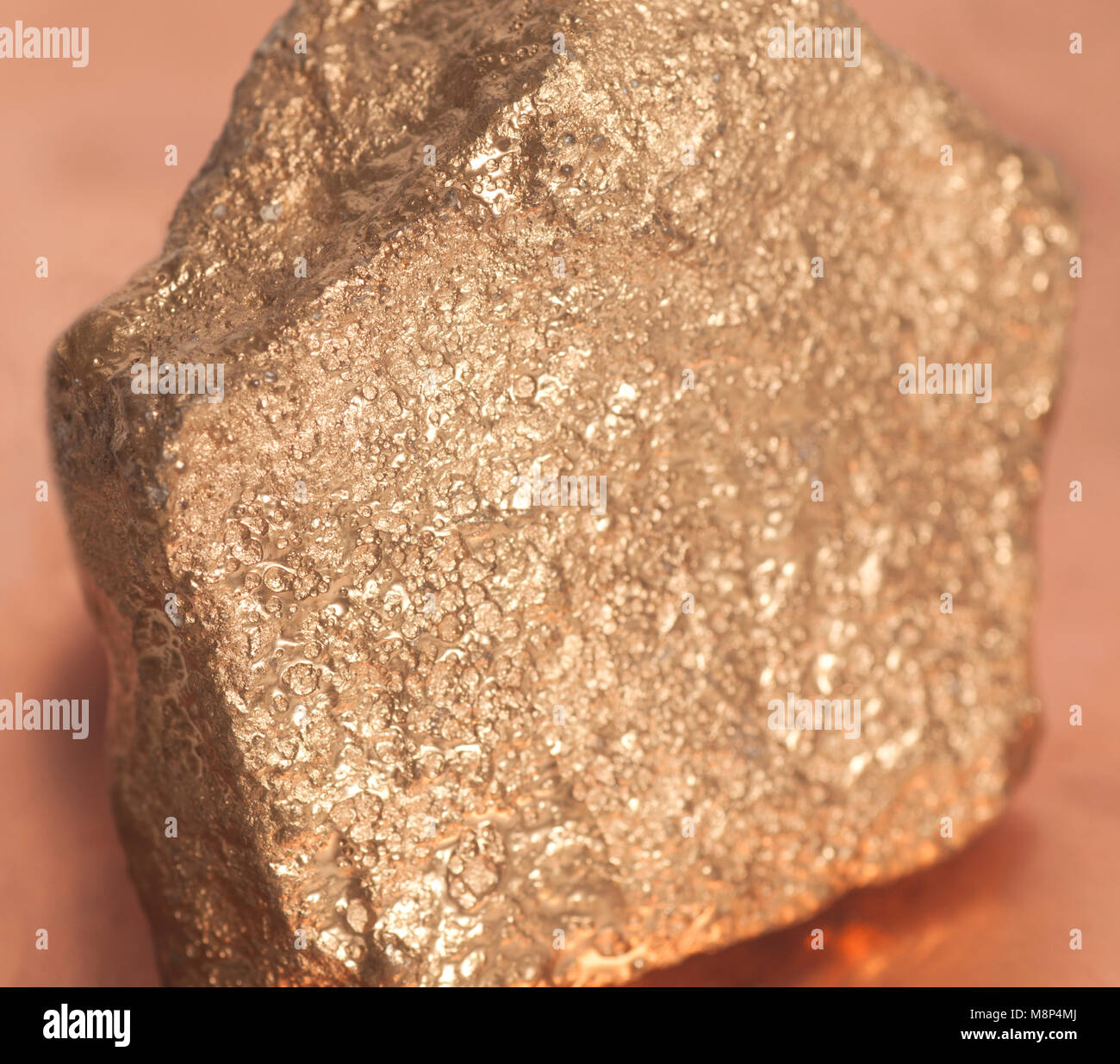 Golden nugget bar on a copper background Stock Photo - Alamy